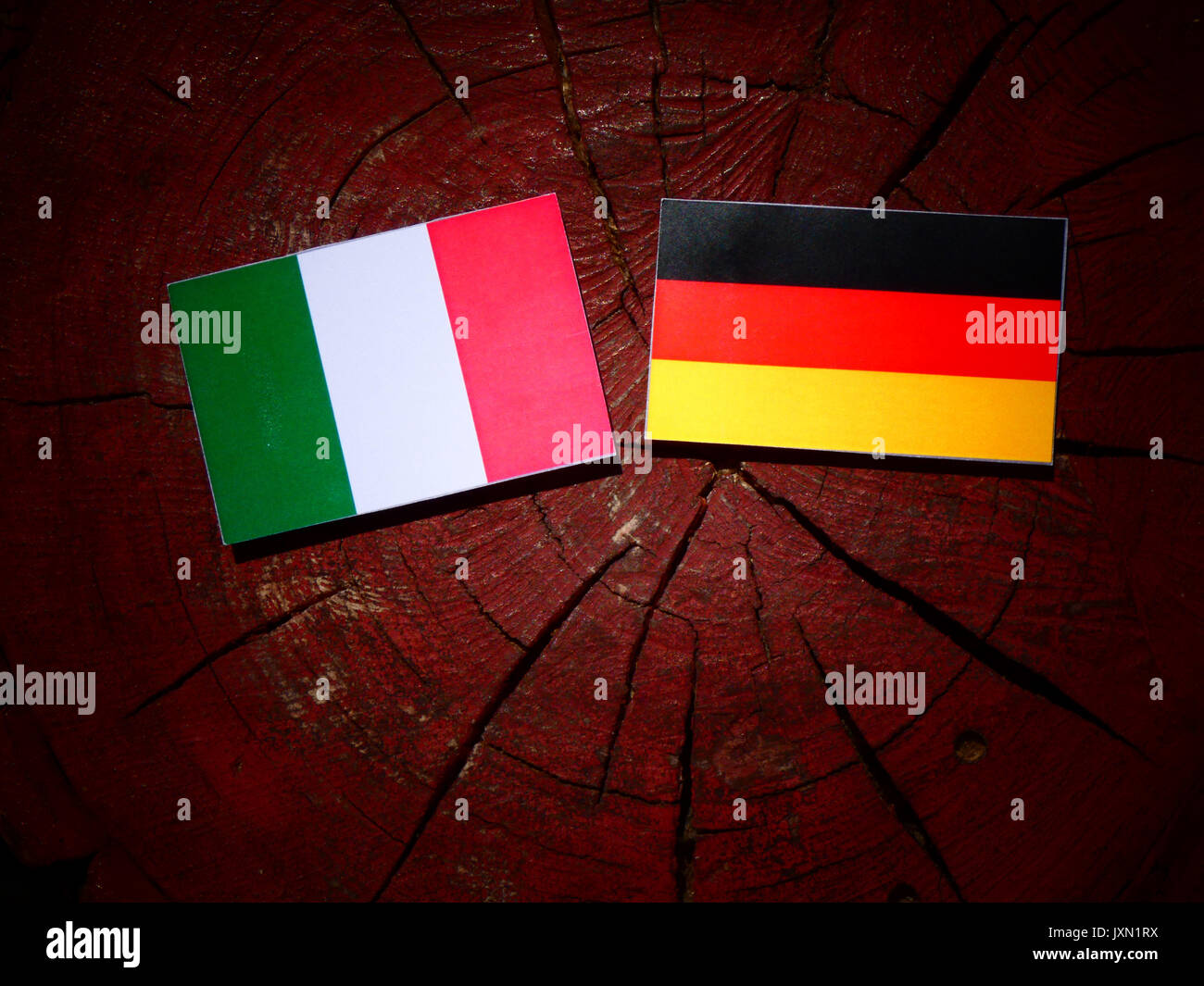 Italian flag with German flag on a tree stump isolated Stock Photo - Alamy