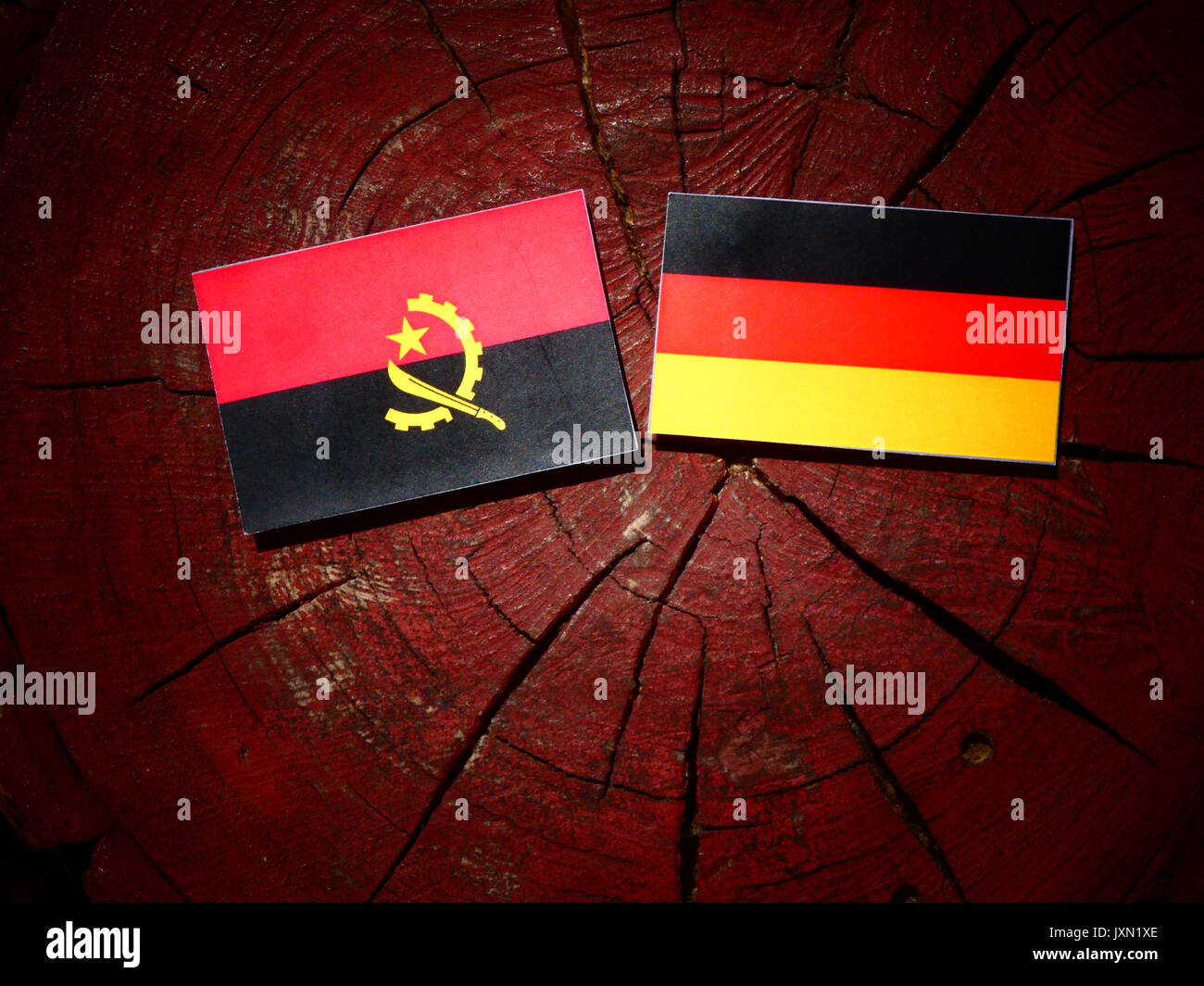 Angolan flag with German flag on a tree stump isolated Stock Photo - Alamy