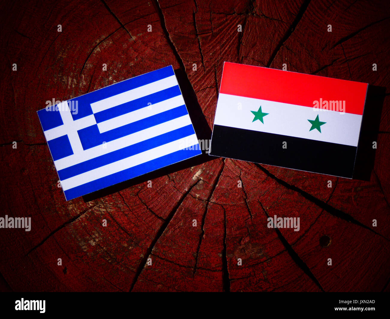 Greek flag with Syrian flag on a tree stump isolated Stock Photo - Alamy