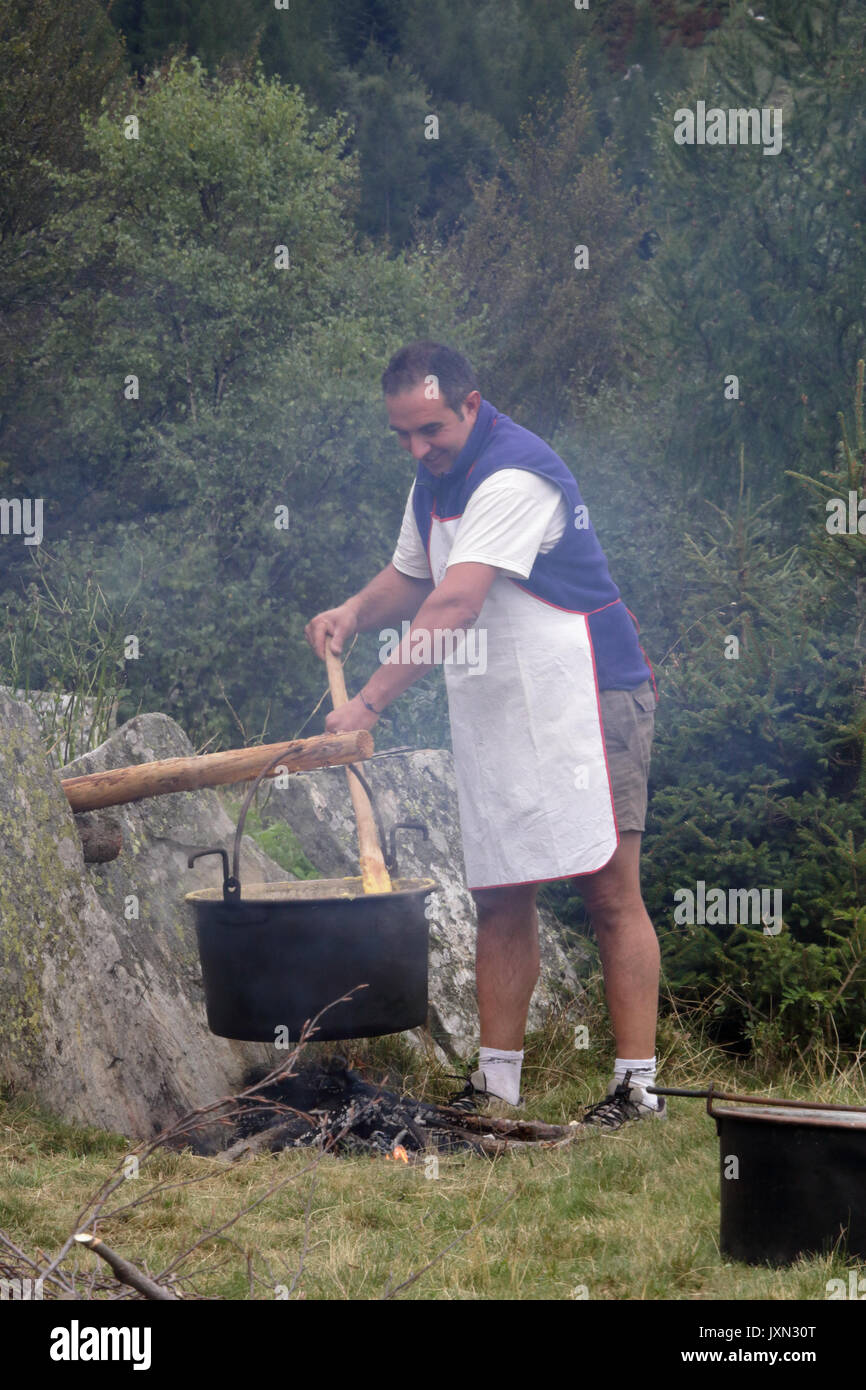 Italian cornmeal polenta (mush) being cooked on slow flame in a pot on ...