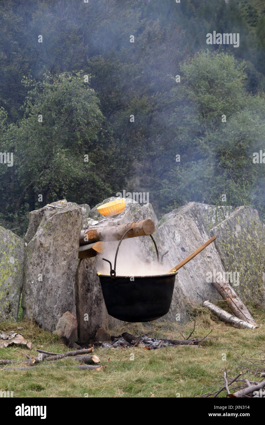 Italian cornmeal polenta (mush) being cooked on slow flame in a pot on ...