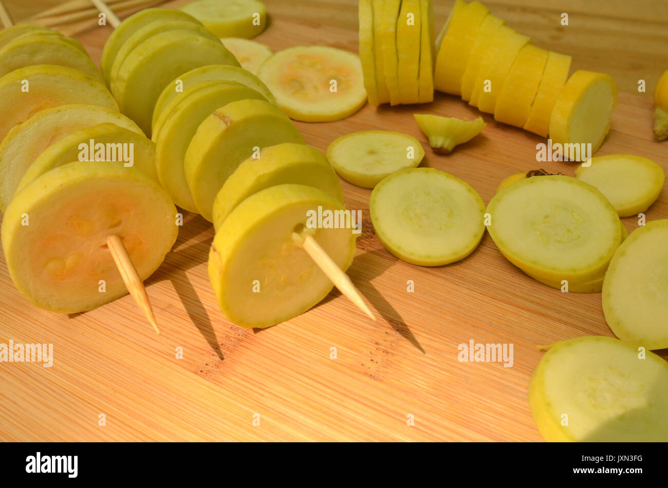 sliced yellow squash on outdoor picnic table under shade tree --squash ...