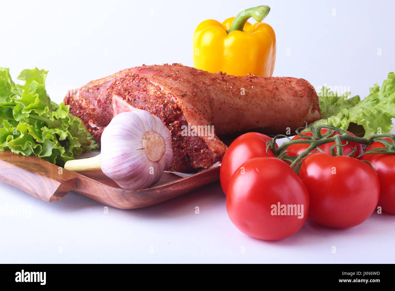 Raw pork knuckle and vegetables, garlic, tomatoes, bell pepper. spices ...