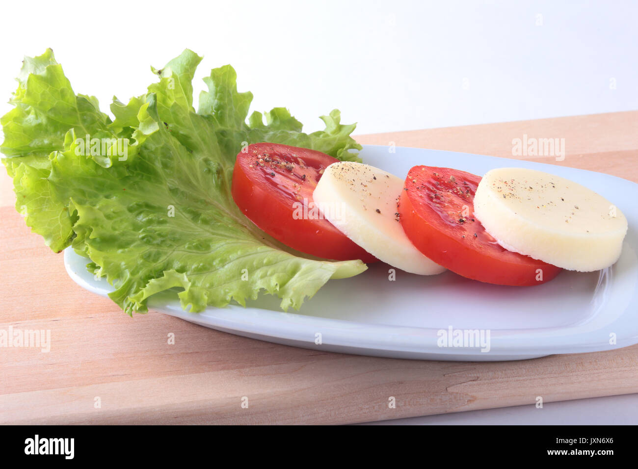 Portion of Mozzarella with Tomatoes, lettuce leaf and Balsamic dressing ...
