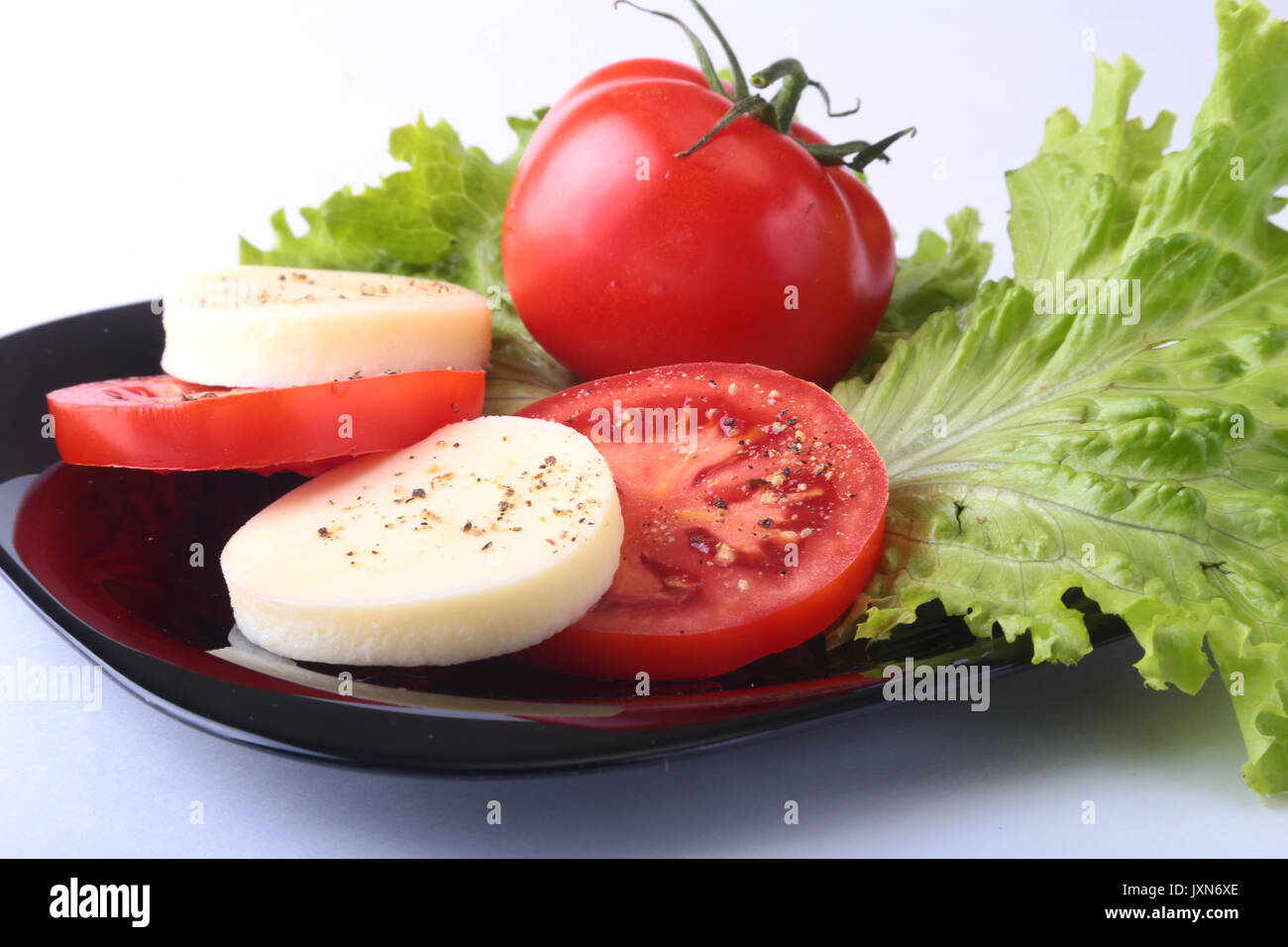 Portion of Mozzarella with Tomatoes, lettuce leaf and Balsamic dressing ...