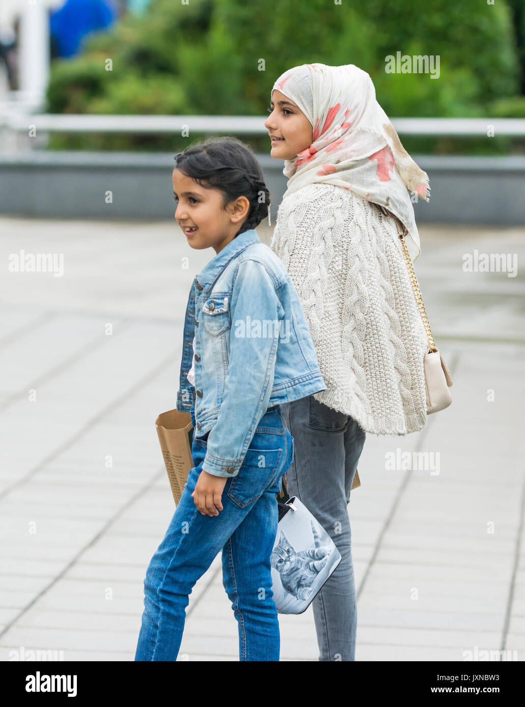 Pair of Asian looking children walking together in the UK Stock Photo ...