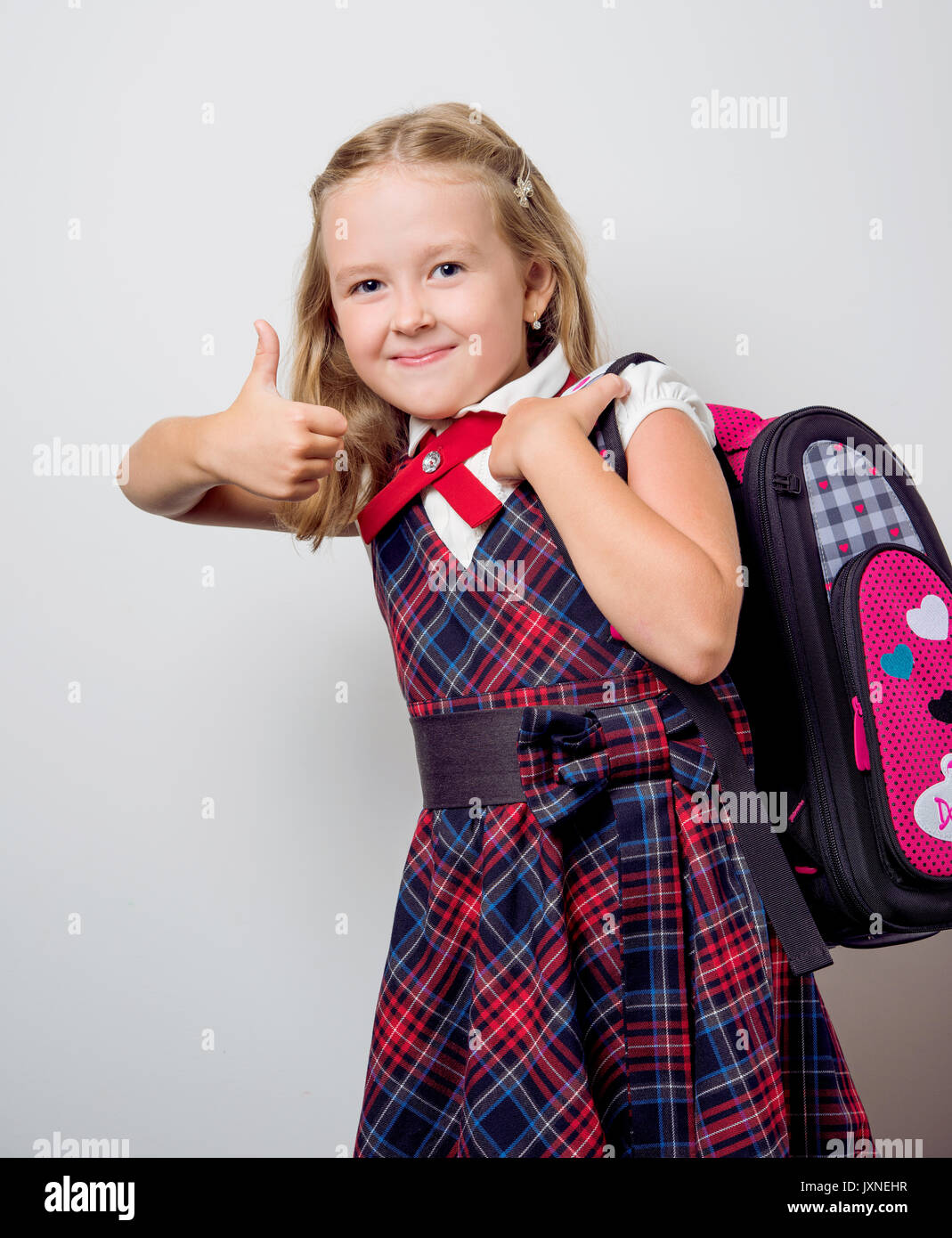 child in a school uniform with a backpack Stock Photo - Alamy