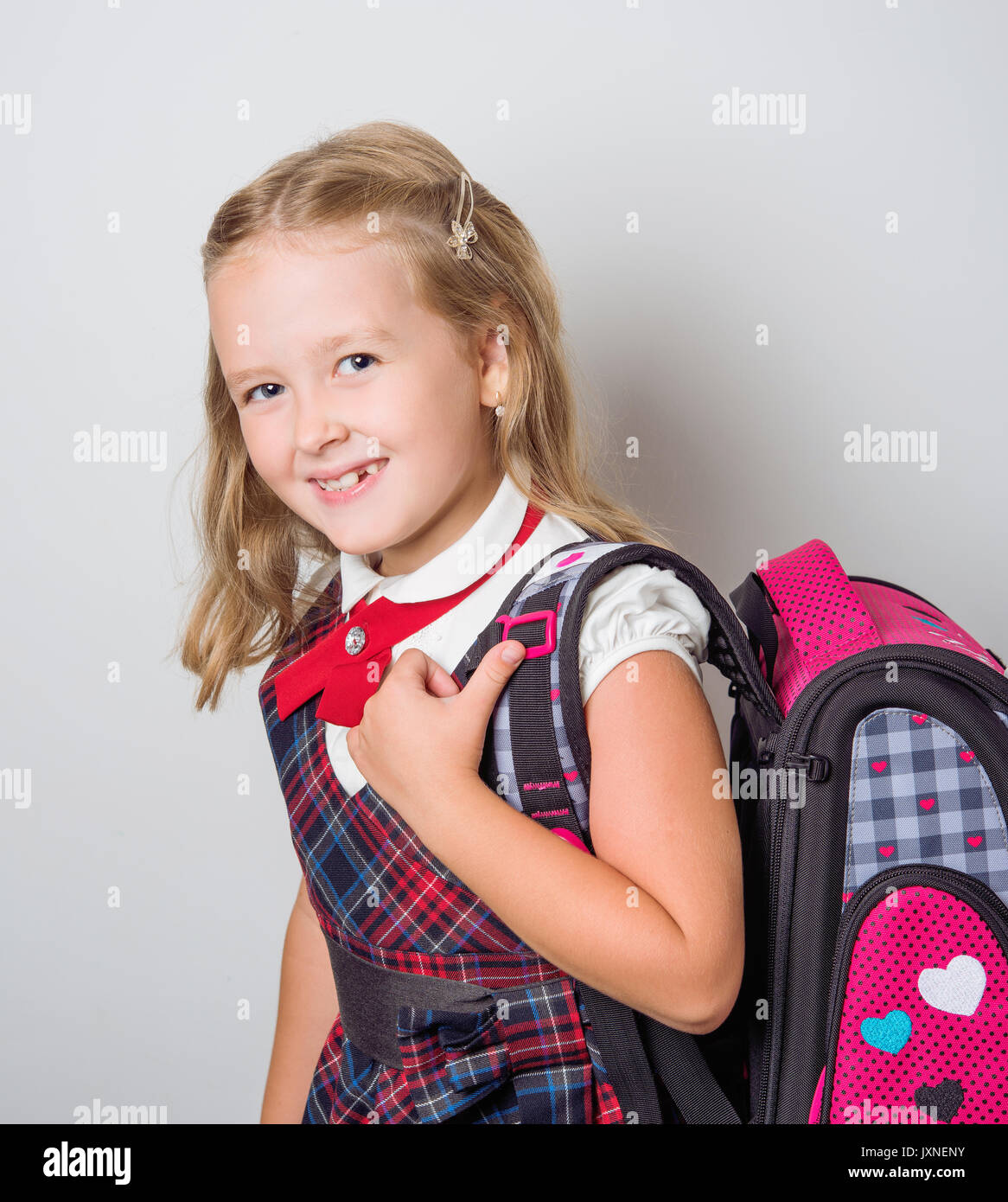 child in a school uniform with a backpack Stock Photo - Alamy