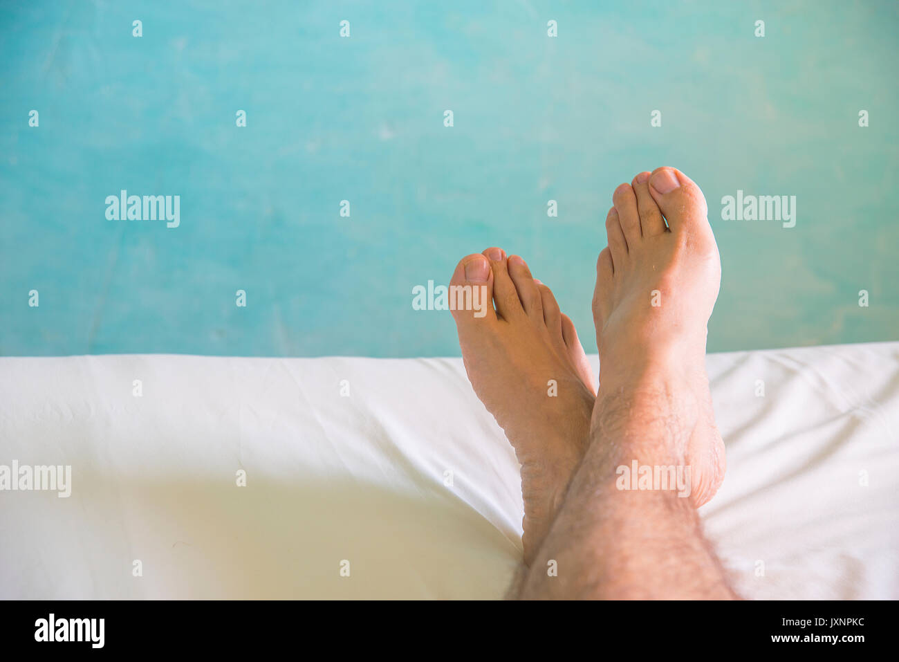 Man's feet lying on bed Stock Photo - Alamy