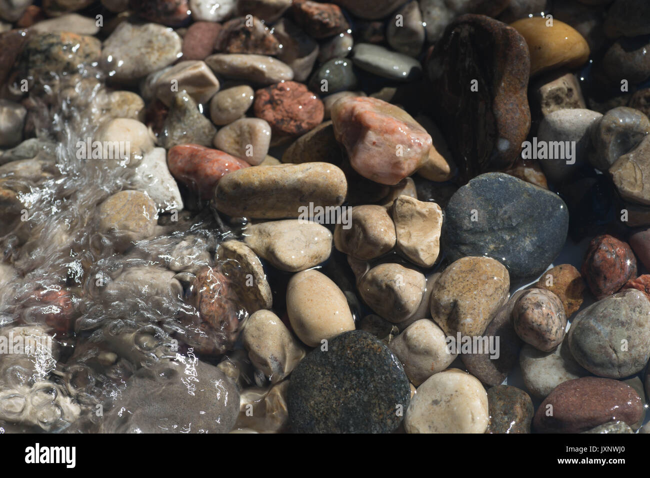 small pebble stones in water background Stock Photo - Alamy
