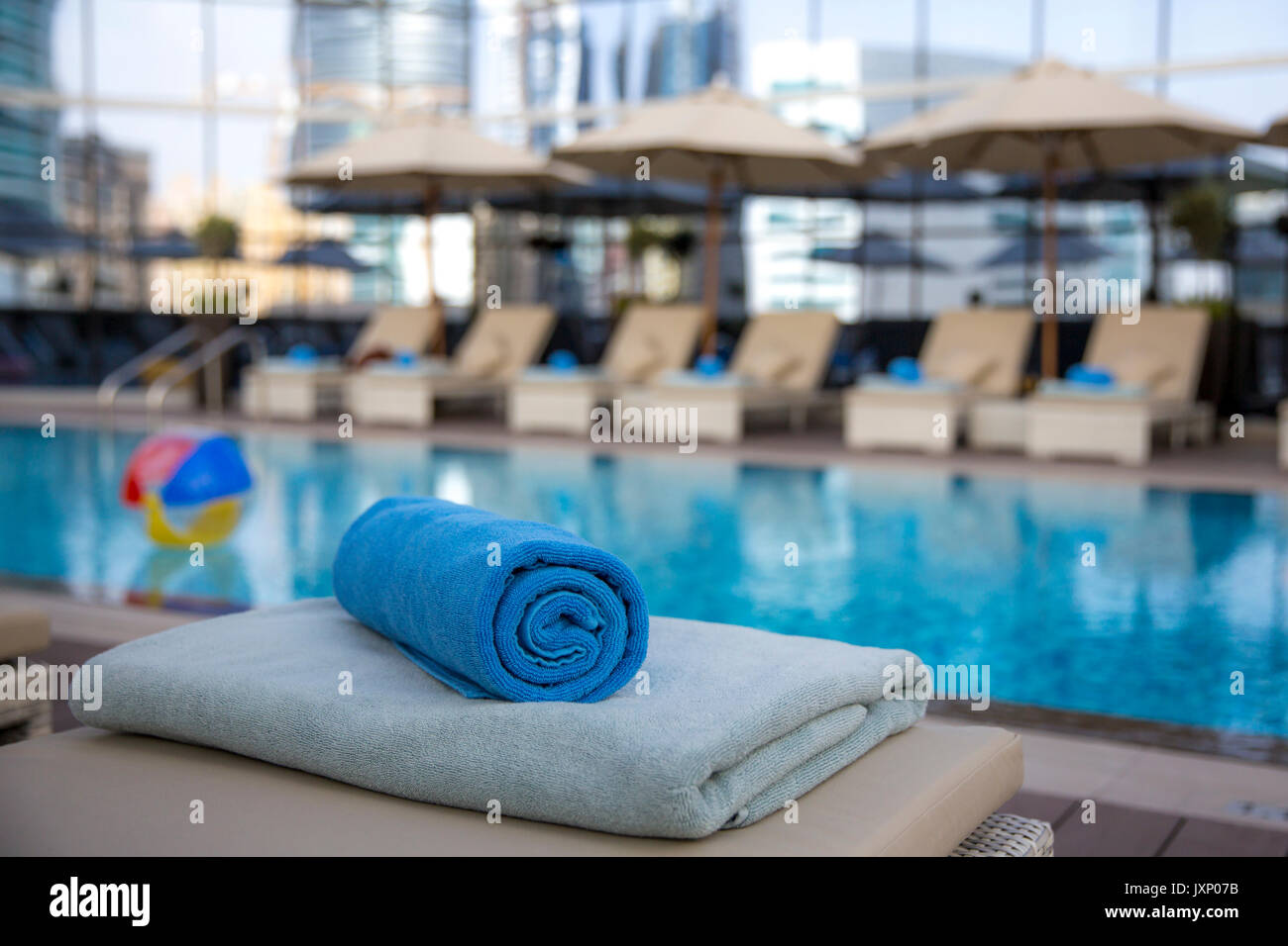towel rolled up ready for guests at a swimming pool in an early morning ...