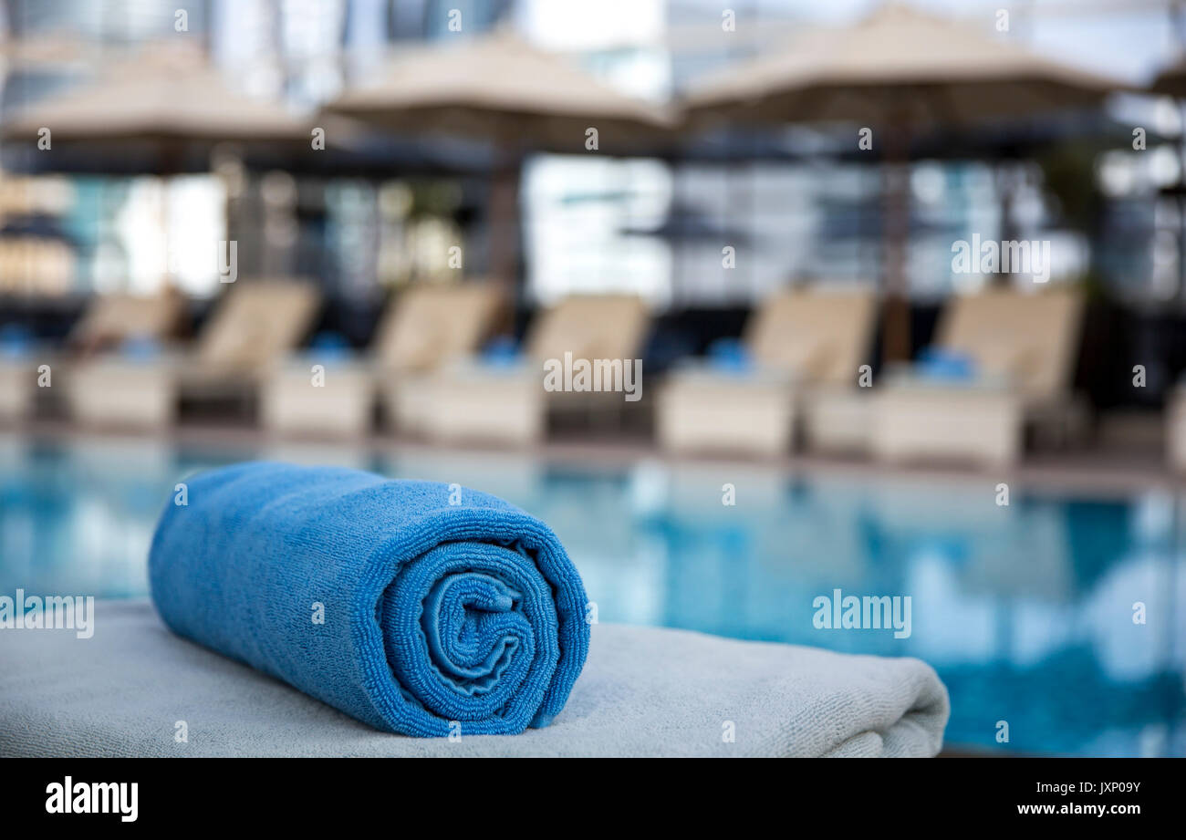 towel rolled up ready for guests at a swimming pool in an early morning ...