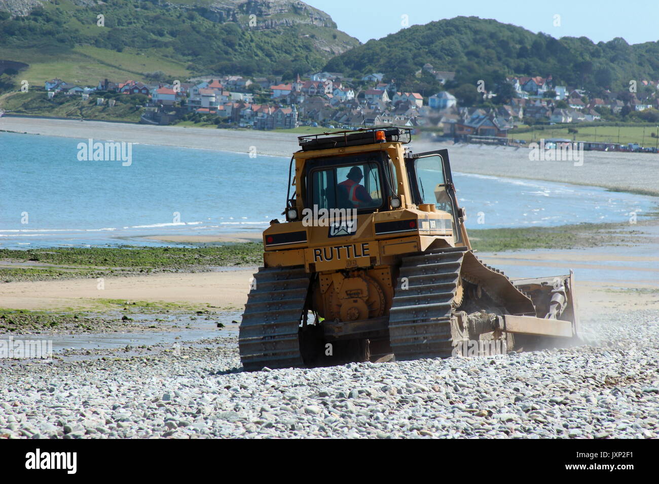 A bulldozer construction coastal defences on Llandudno beach Stock ...