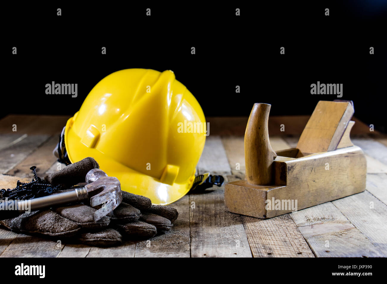 Yellow helmet and carpenter tools. Carpenter and old wooden table ...