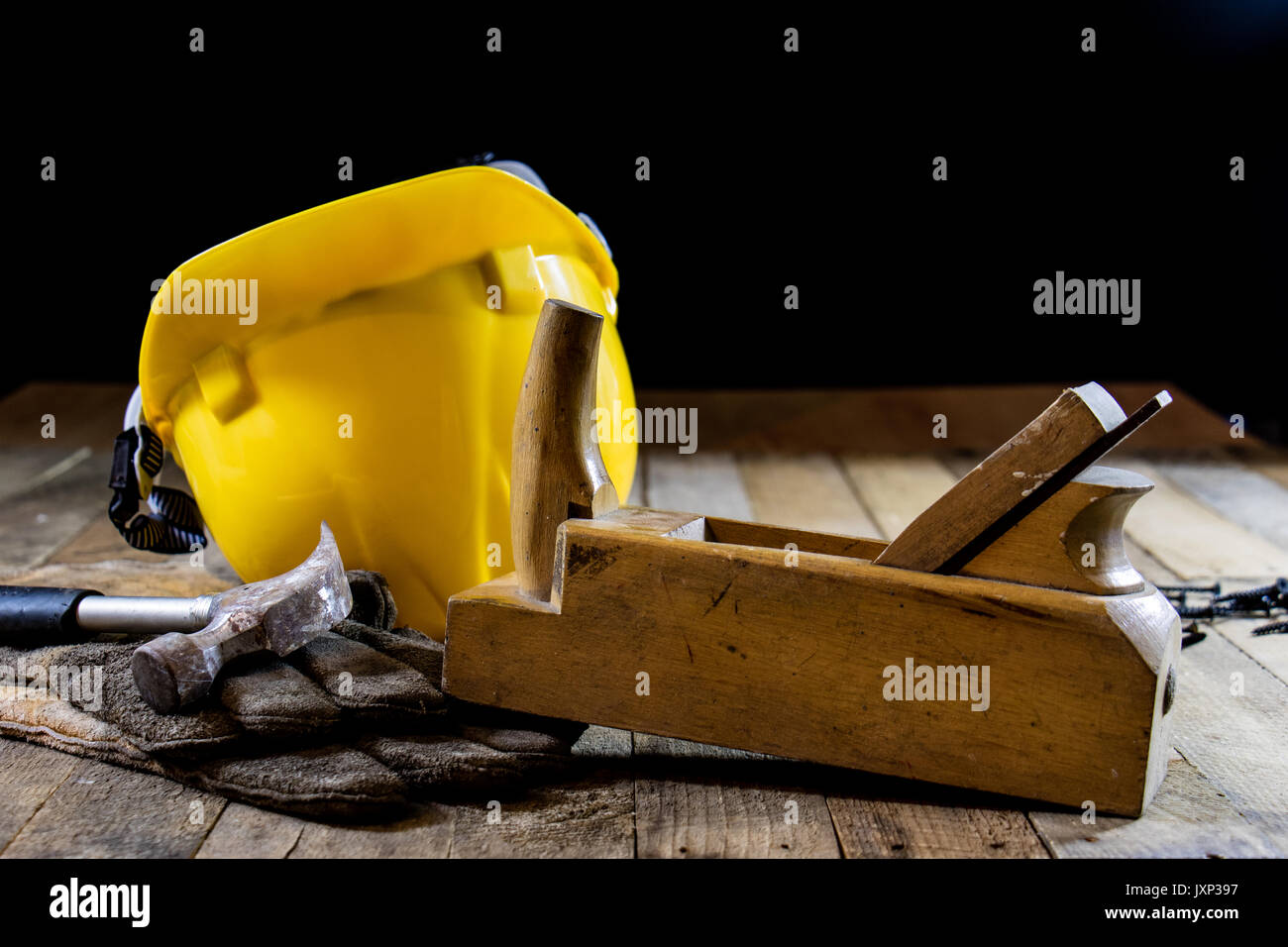 Yellow helmet and carpenter tools. Carpenter and old wooden table ...