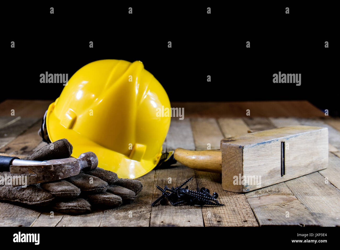 Yellow helmet and carpenter tools. Carpenter and old wooden table ...