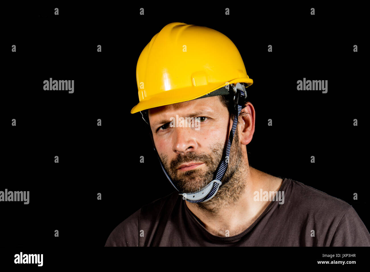 Worker, employee in a helmet. Black beard, black background. Yellow ...