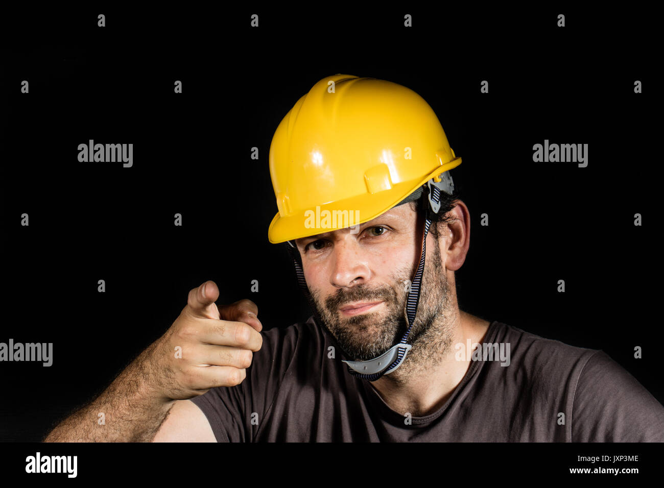 Worker, employee in a helmet. Black beard, black background. Yellow ...