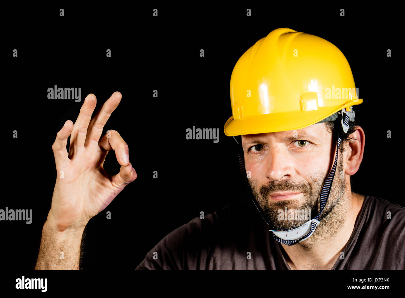 Worker, employee in a helmet. Black beard, black background. Yellow ...