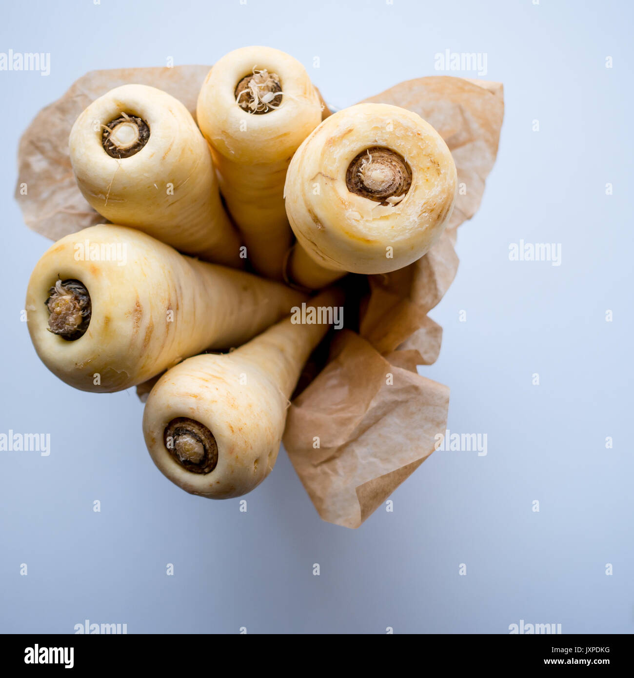 A bunch of parsnips in a cup with baking paper. Top view. Squared ...