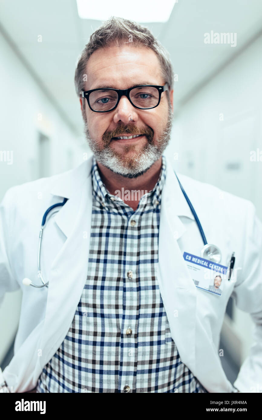 Portrait of happy and relaxed doctor standing in hospital. Man in lab ...