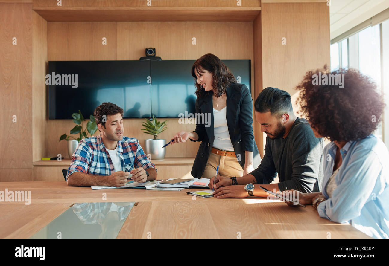 Professionals sitting around conference table hi-res stock photography ...