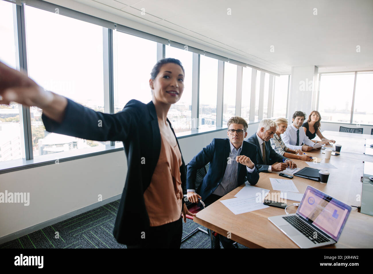 Corporate professionals sitting around conference table and ...
