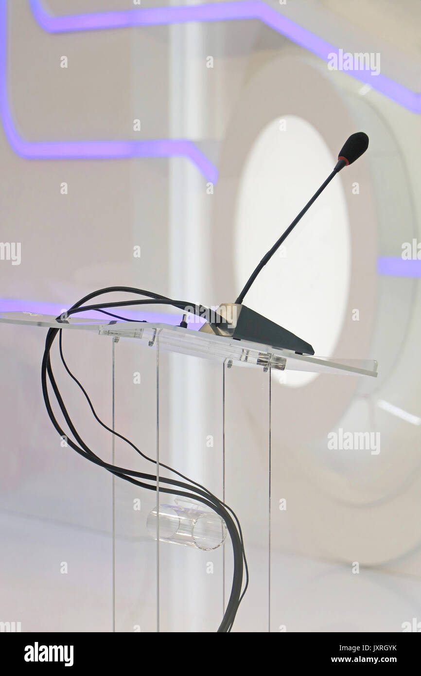 Modern conference podium with microphone on glass stand Stock Photo - Alamy
