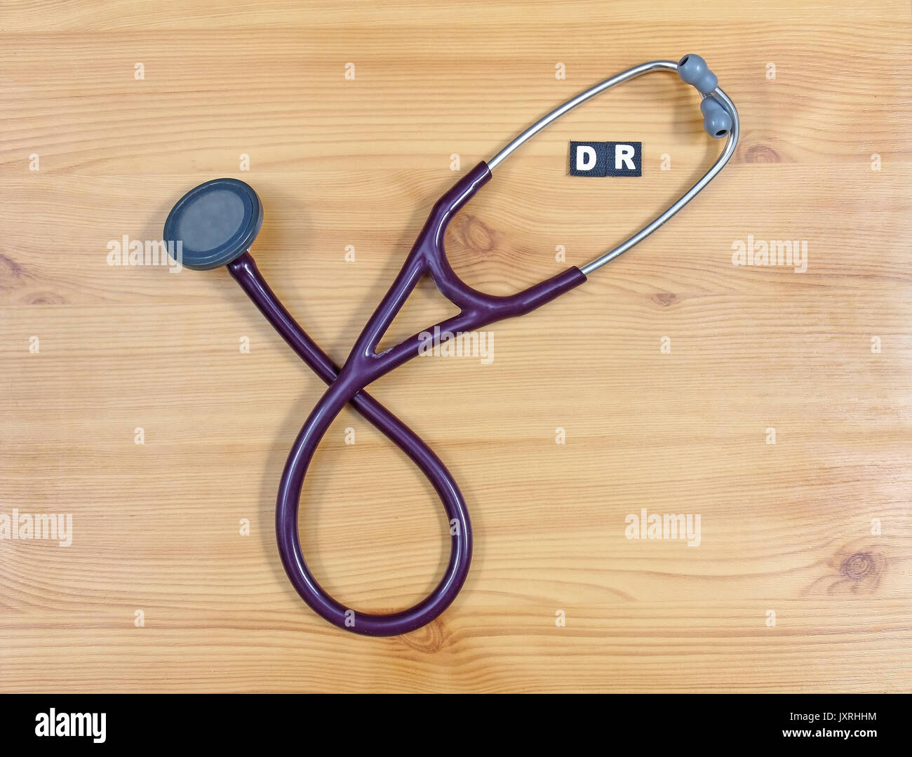 Purple cardiologist stethoscope with DR letters on wooden background ...