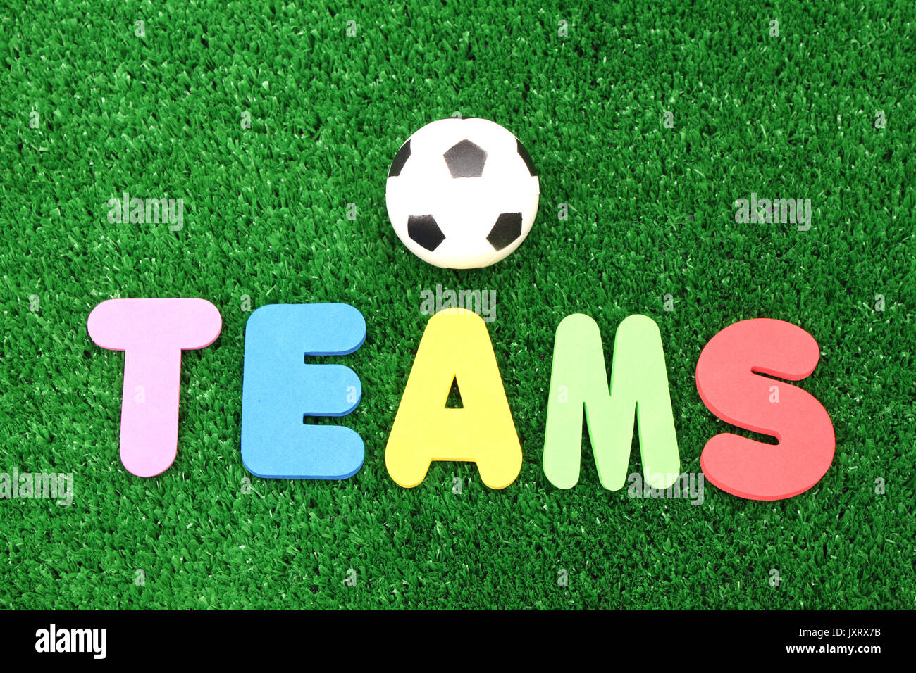 Teams ball on atificial turf - word plastic colours Stock Photo - Alamy