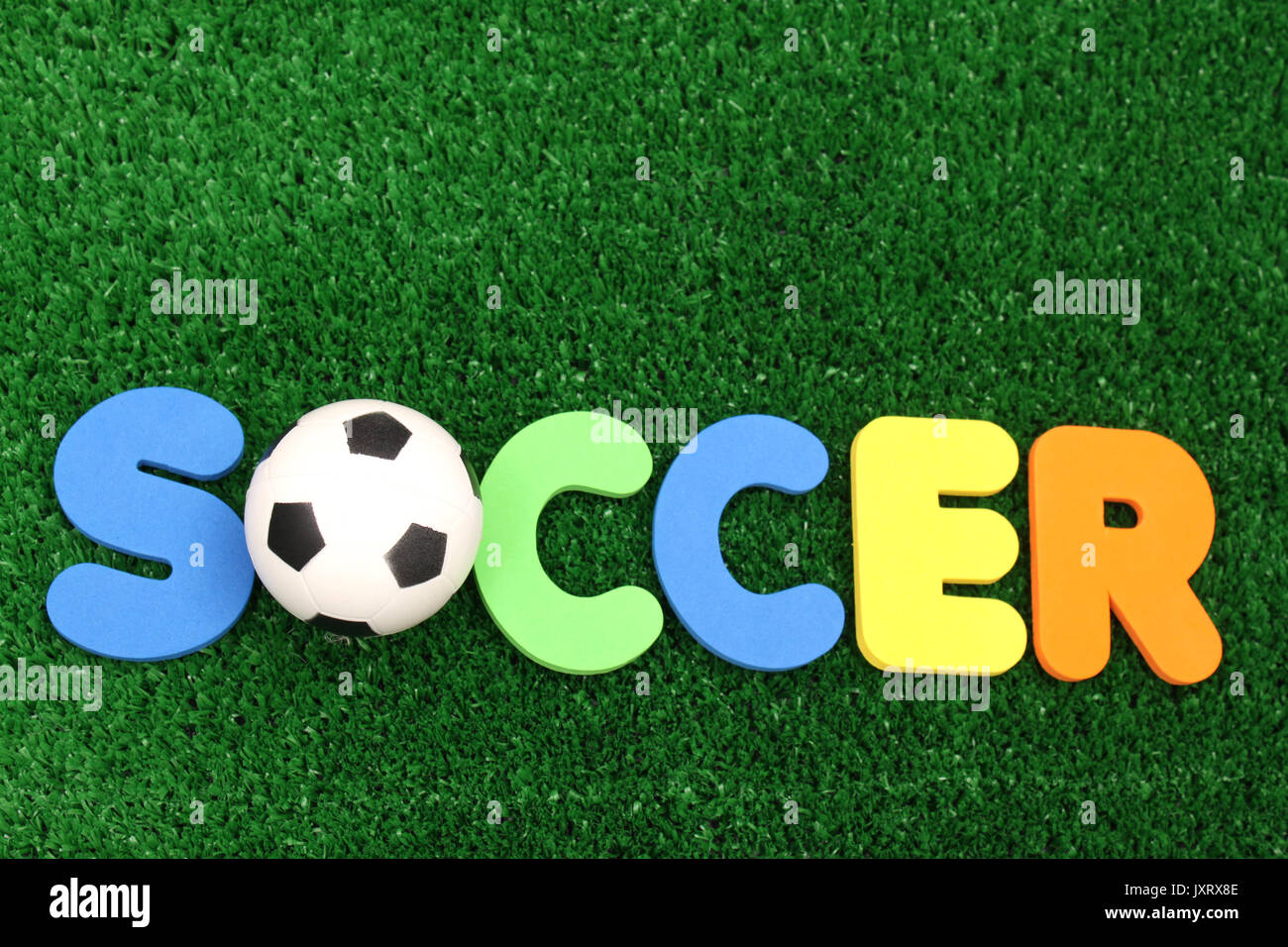Soccer ball on atificial turf - word plastic colours Stock Photo - Alamy