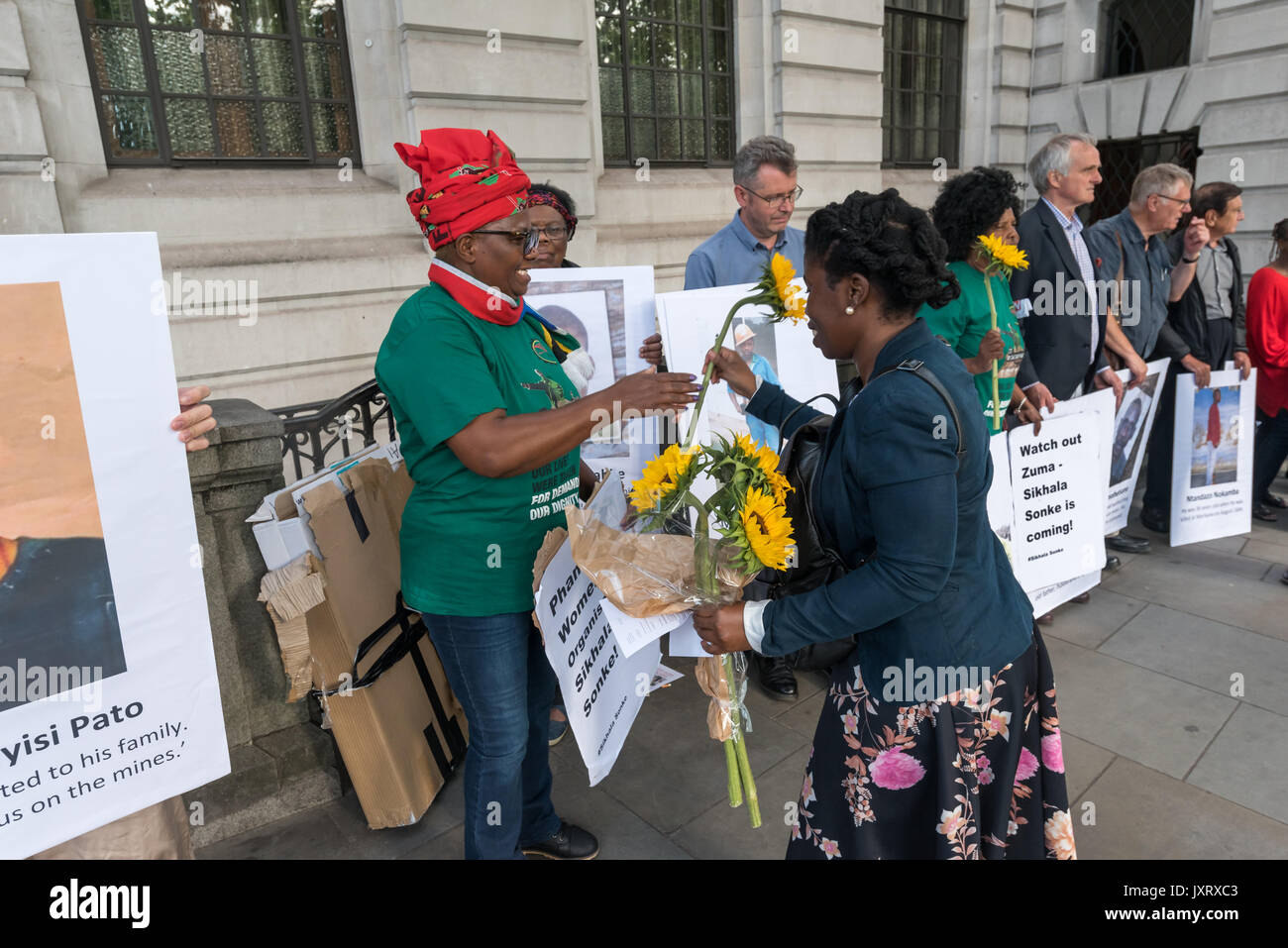 London, UK. 16th August 2017. A woman hands a sunflower to Primrose ...