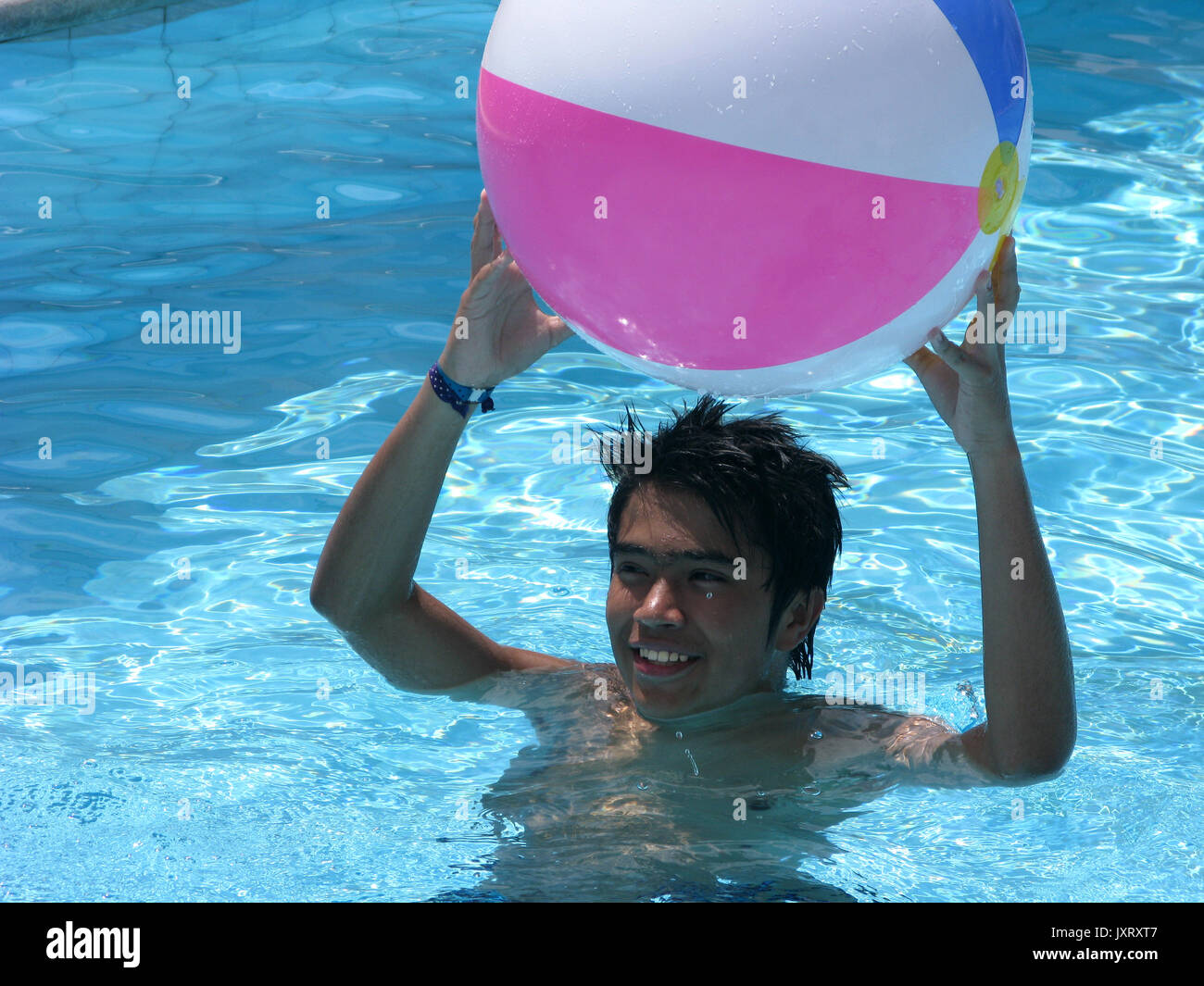 Man young playing in pool with a beach ball Stock Photo - Alamy