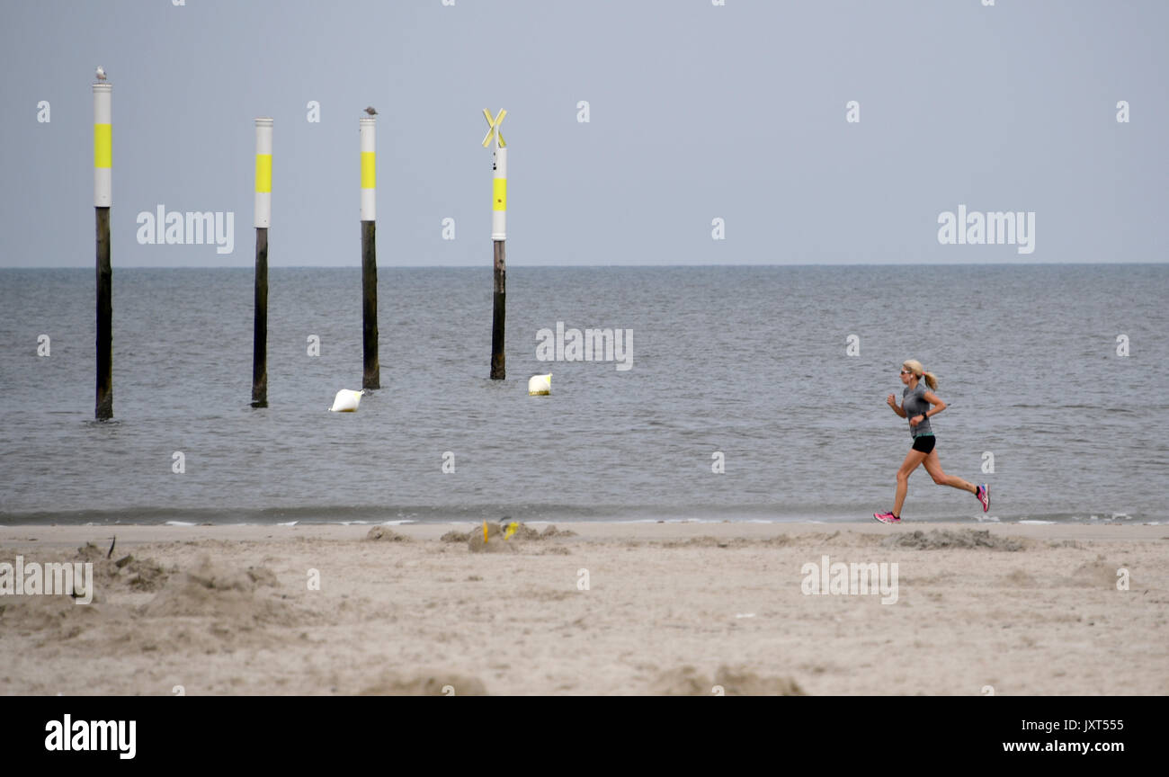 A jogger is running at the beach of the North Sea in St. Peter-Ording ...