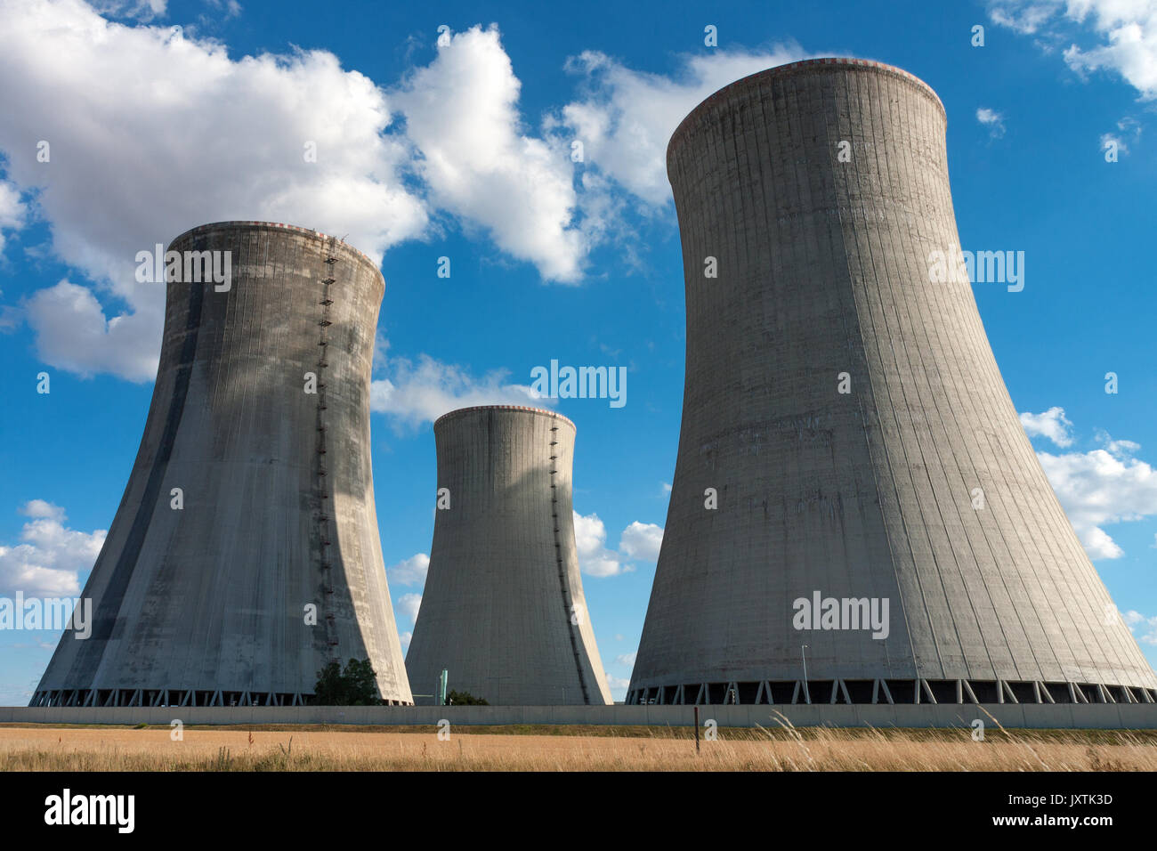 Three chimneys of nuclear power station in the summer day, cooling ...