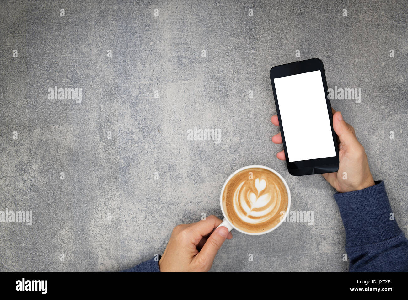 Right hand holding a telephone and left hand holding a cup of coffee ...