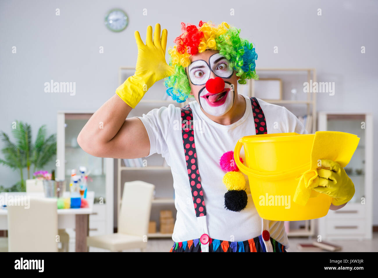 Funny clown doing cleaning at home Stock Photo - Alamy
