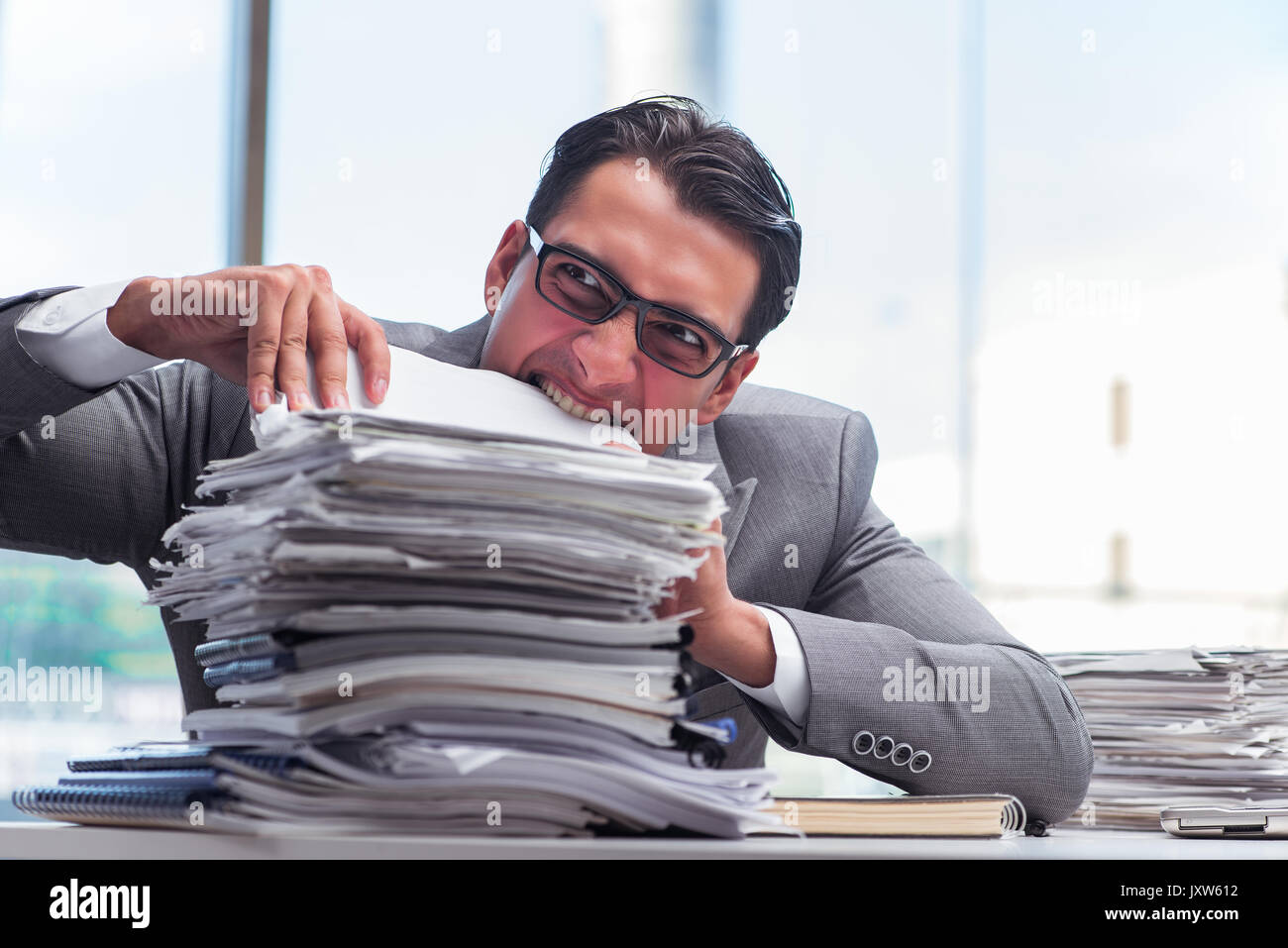 Busy angry businessman with heaps of paper Stock Photo - Alamy