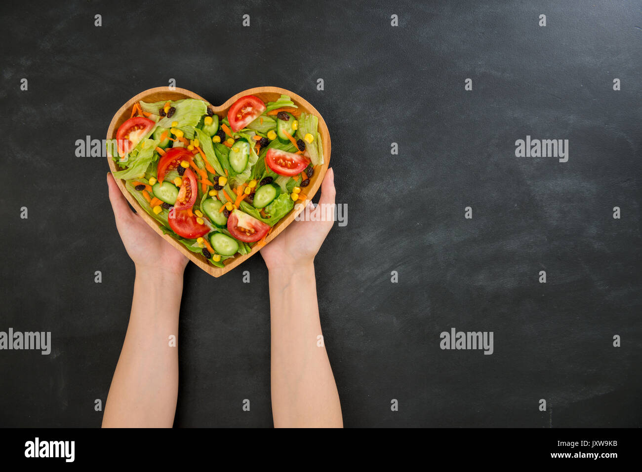 high angle view photo of beautiful hands holding heart shaped wooden ...