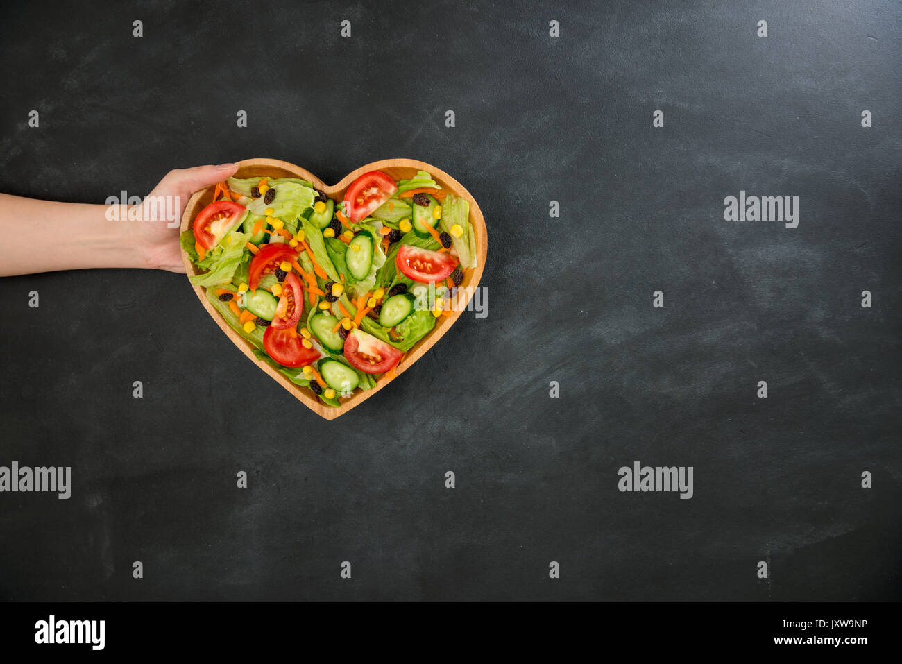 somebody hand showing nutrition vegetable healthy food in wooden heart ...