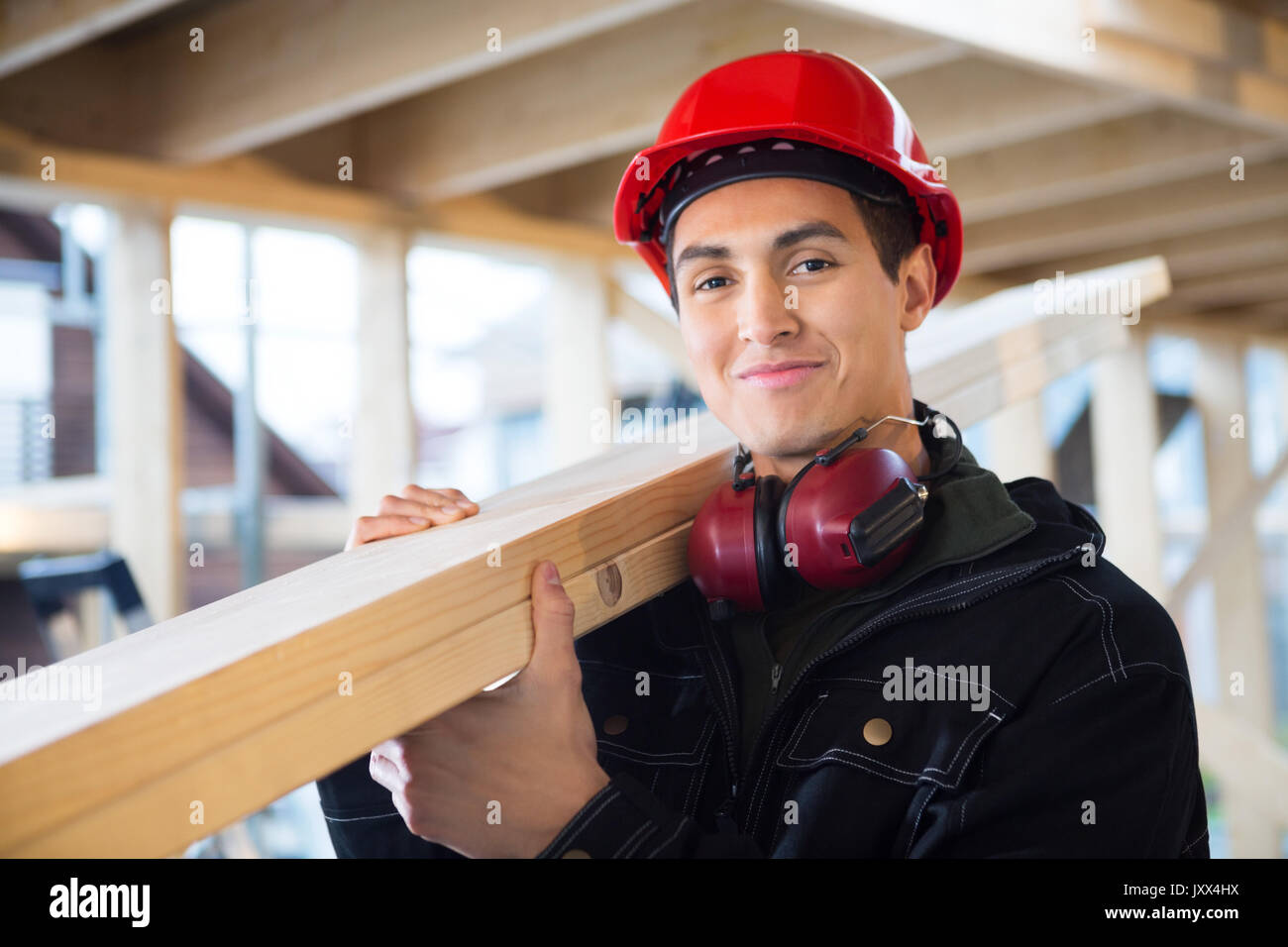 Carpenter Carrying Wood On Shoulder At Construction Site Stock Photo ...