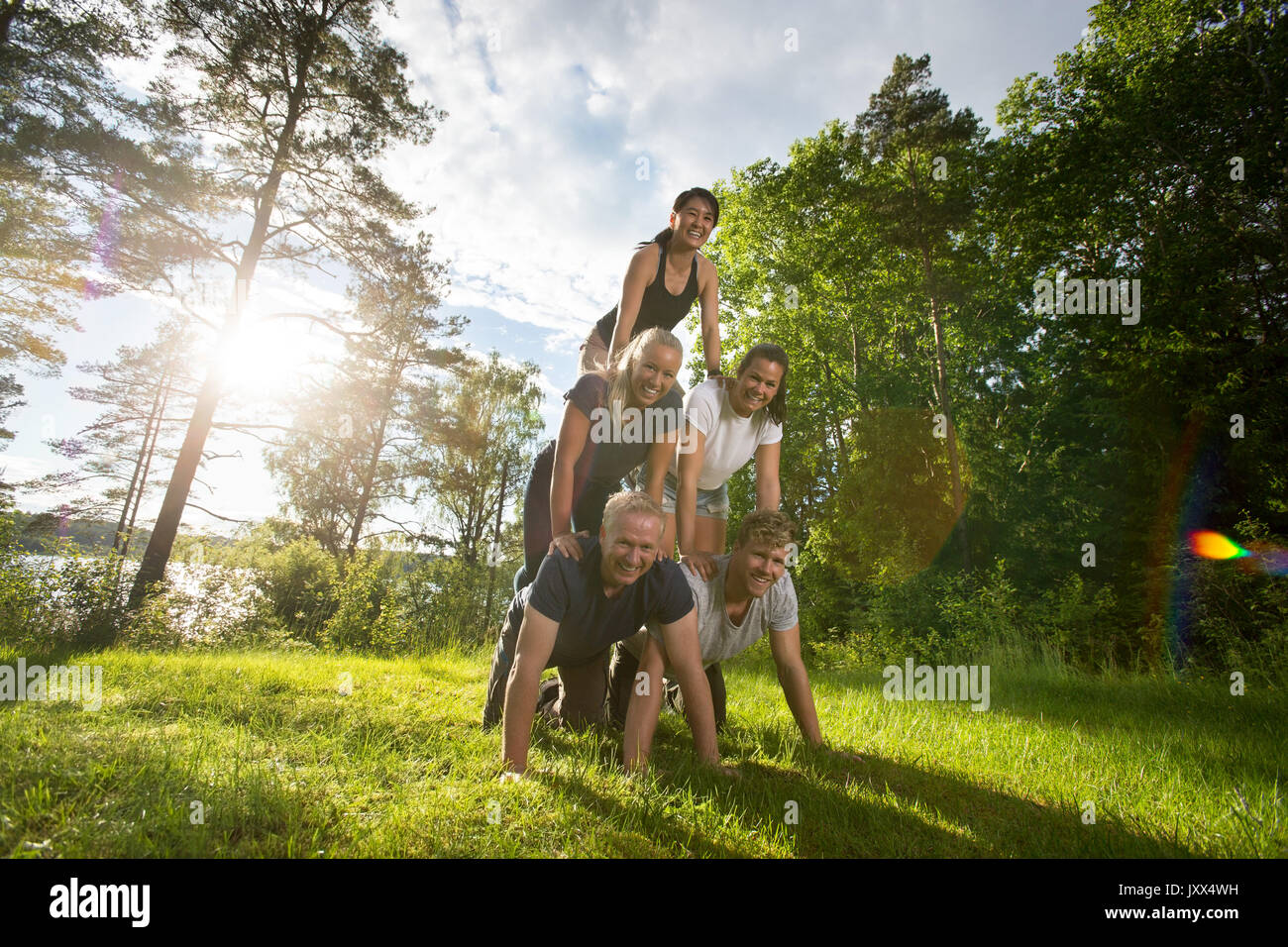 Portrait Of Happy Friends Making Human Pyramid On Field Stock Photo - Alamy
