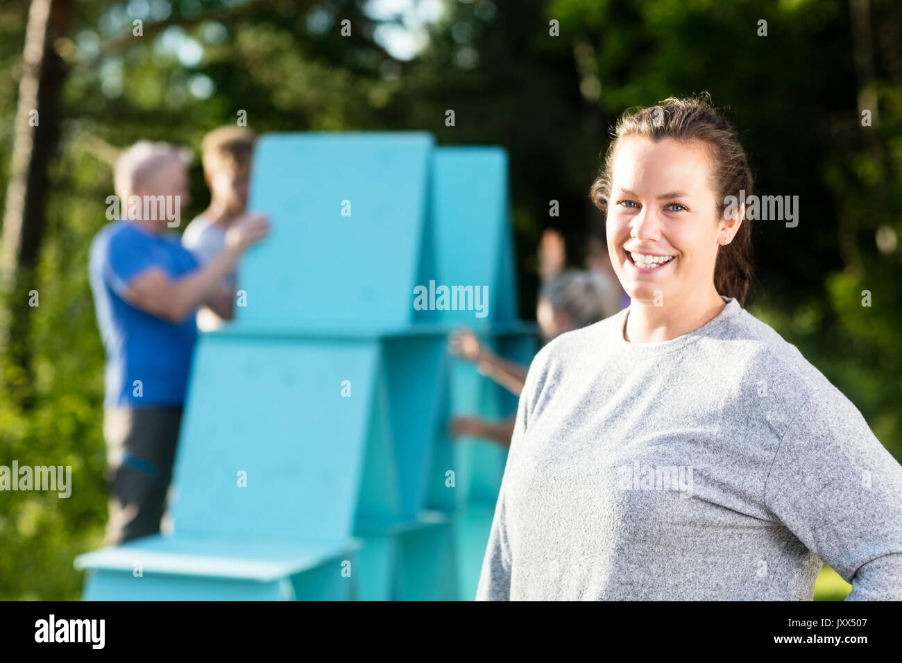 Woman Smiling While Friends Making Pyramid Of Planks Stock Photo - Alamy