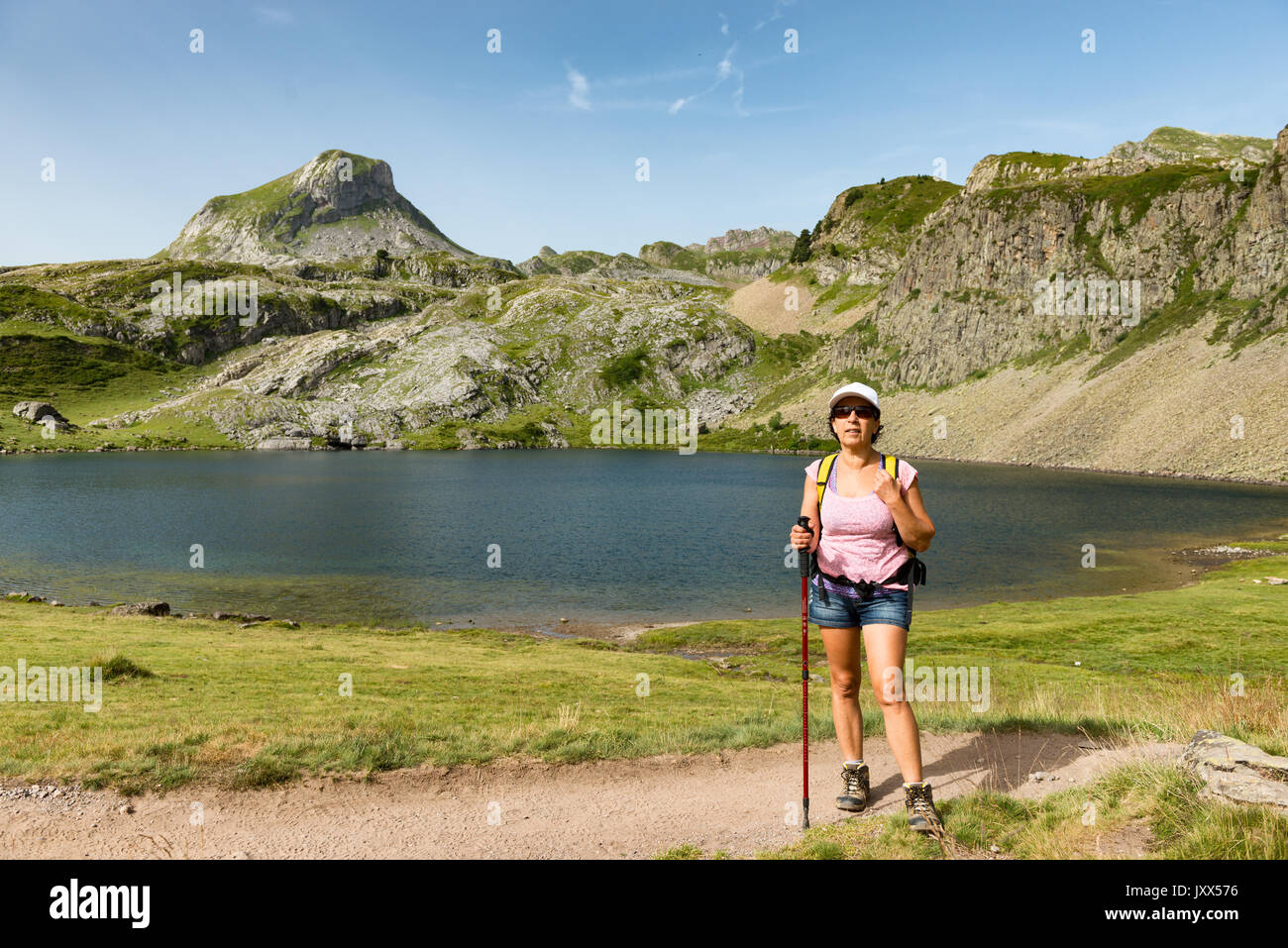 A woman hiking near a mountain lake in the French Pyrenees Stock Photo ...