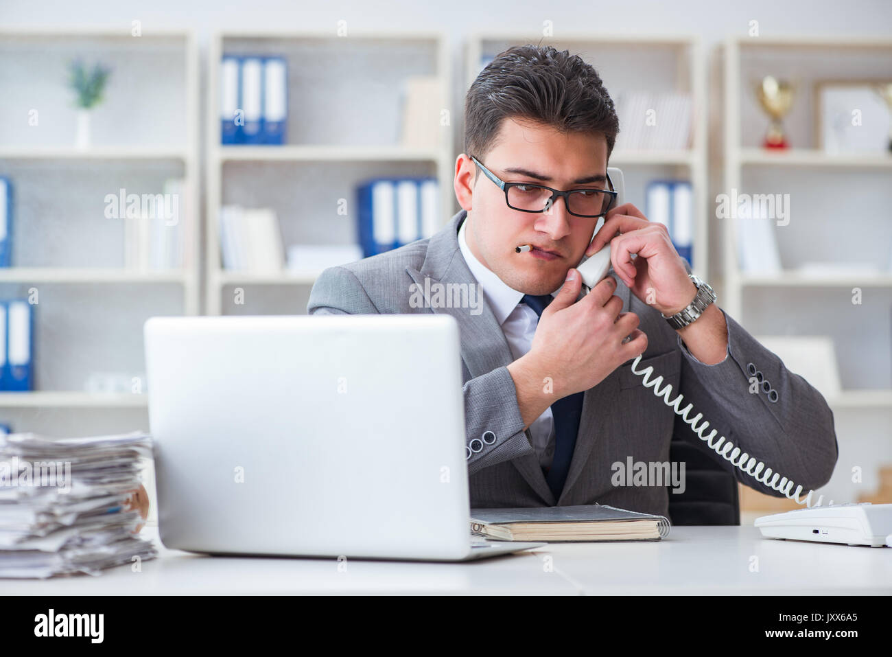 Businessman smoking in office at work Stock Photo - Alamy