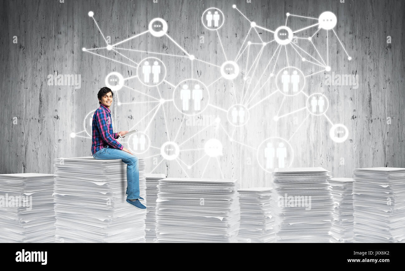 Attractive man sitting on pile of paper documents Stock Photo - Alamy