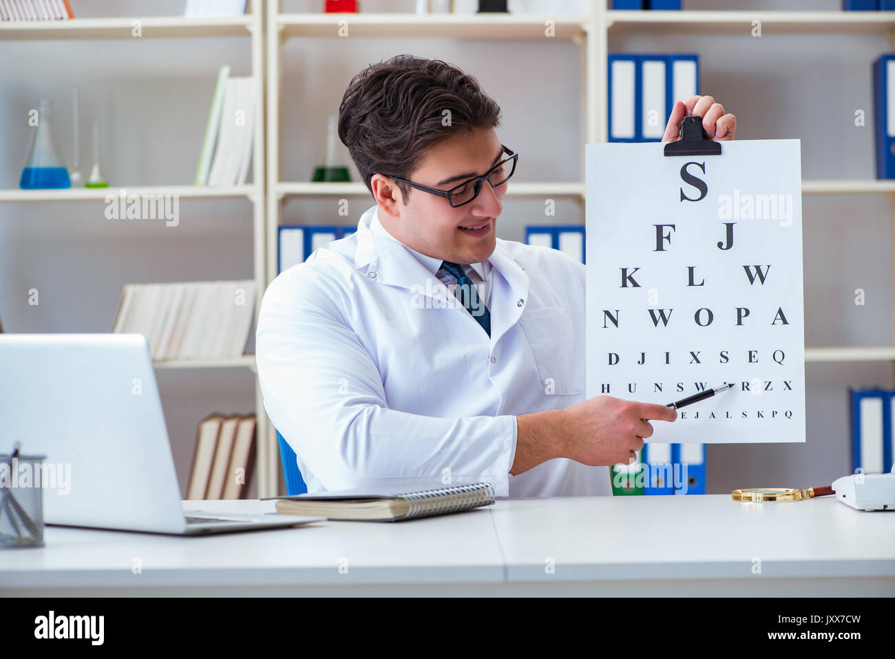 Doctor optician with letter chart conducting an eye test check Stock ...