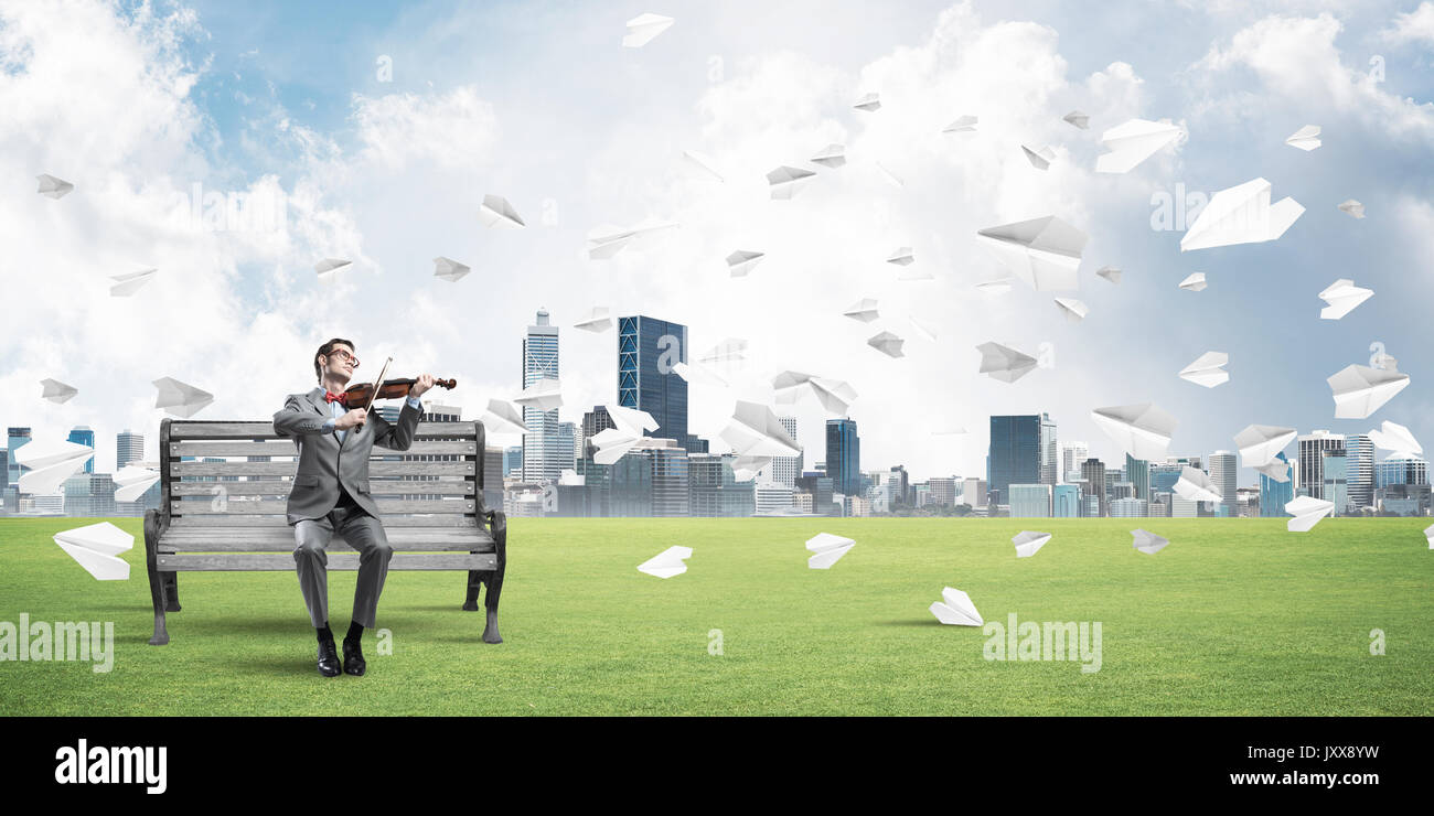 Handsome violinist in park on wooden bench play his melody Stock Photo ...