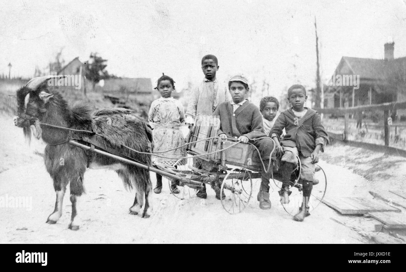 A young African American boy and girl with neutral expressions stand by ...