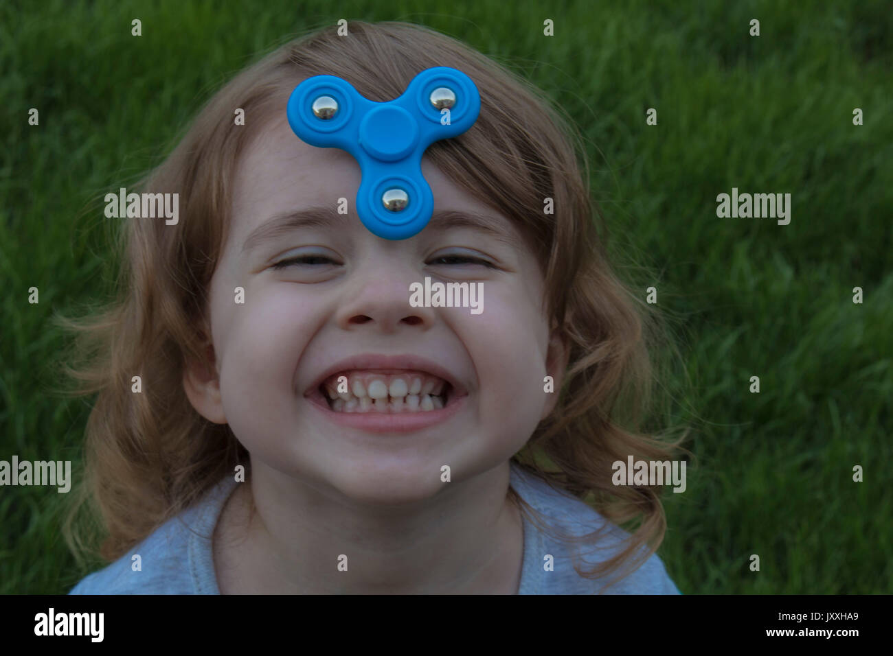 portrait little beautiful girl is playing blue spinner Stock Photo - Alamy